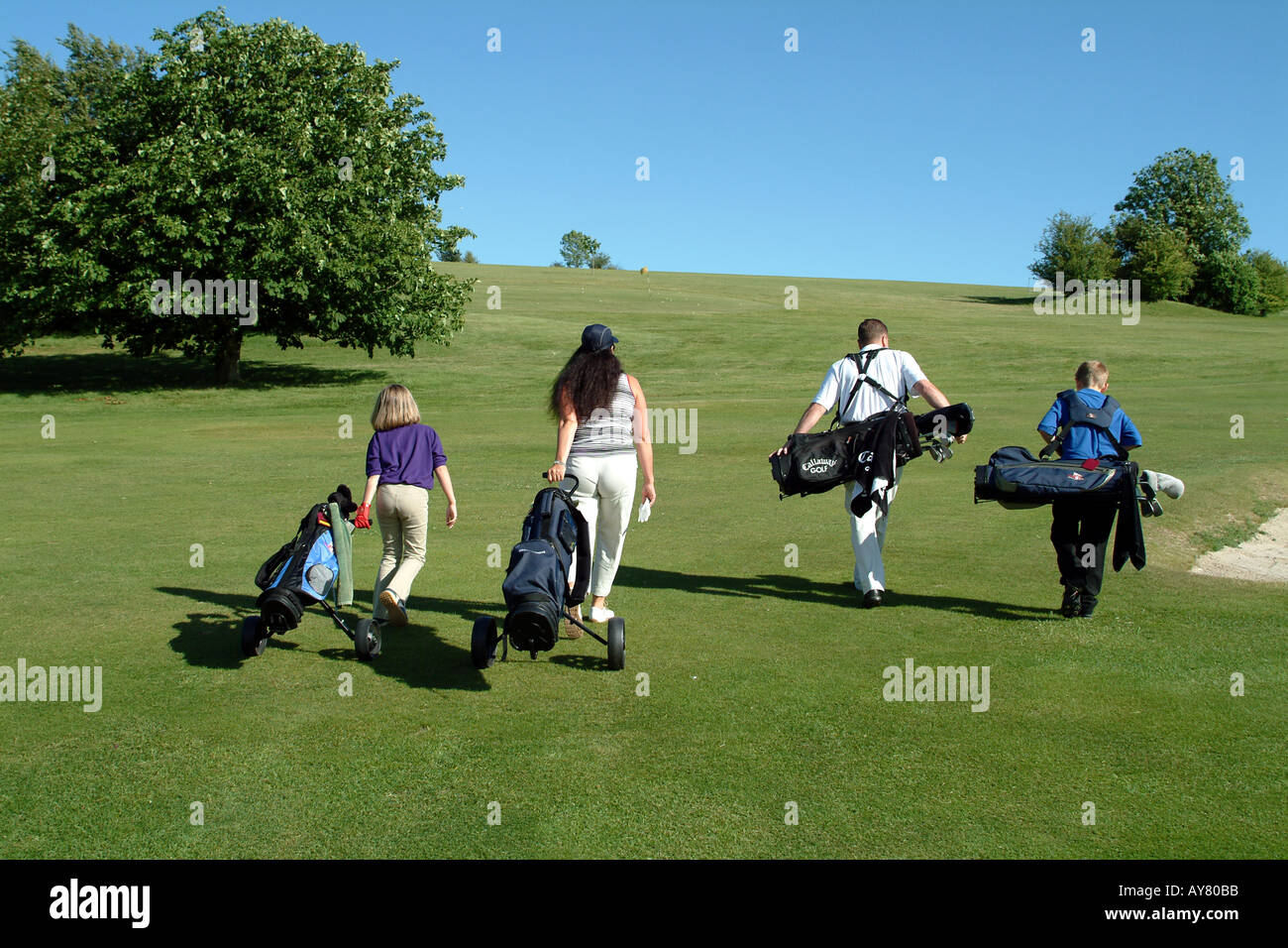 Golfing Family Children with Parents and Trollies on a Golf Course in ...