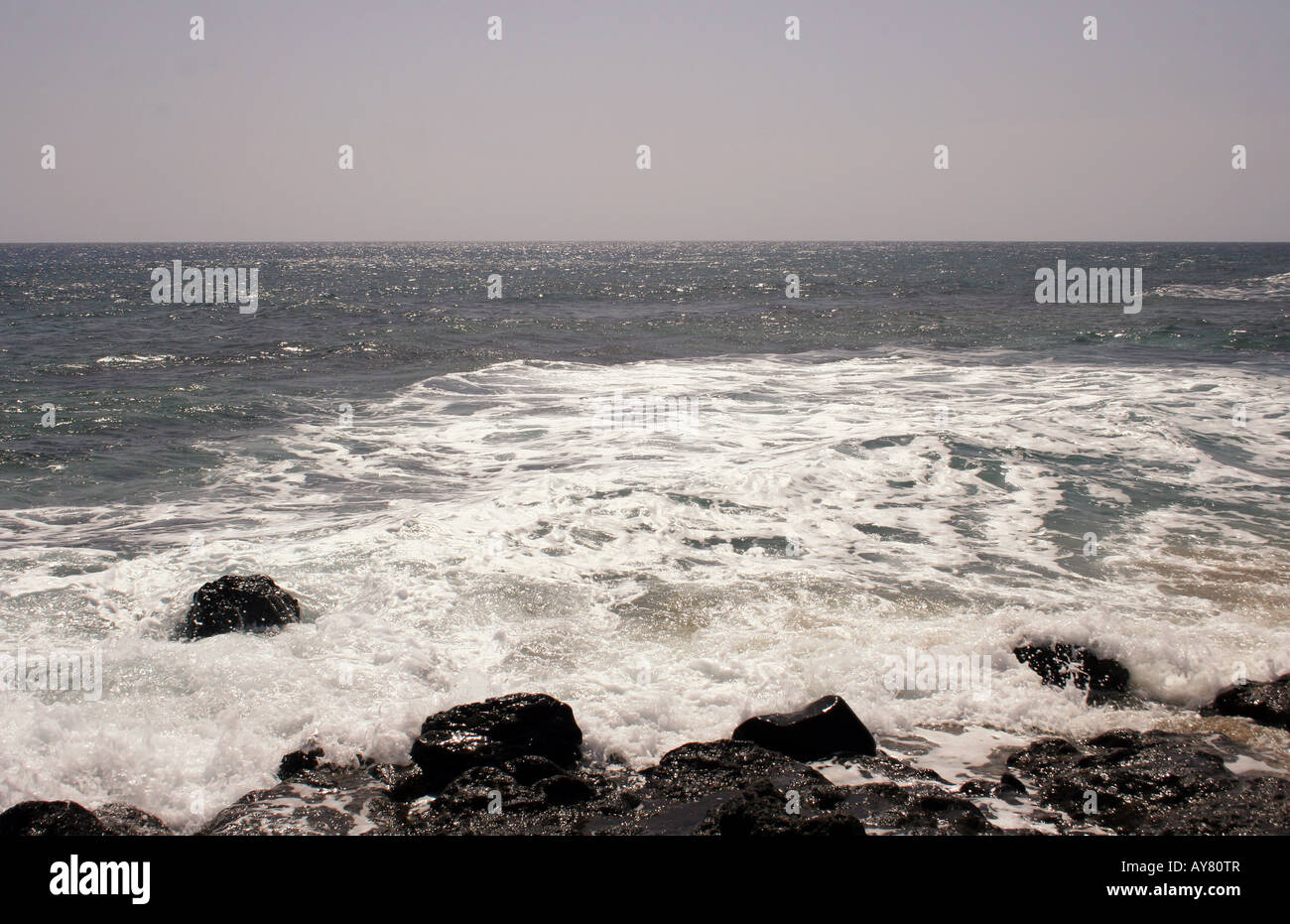 A SEASCAPE WITH WHITE SURF BREAKING ON THE ROCKY SHORELINE Stock Photo ...