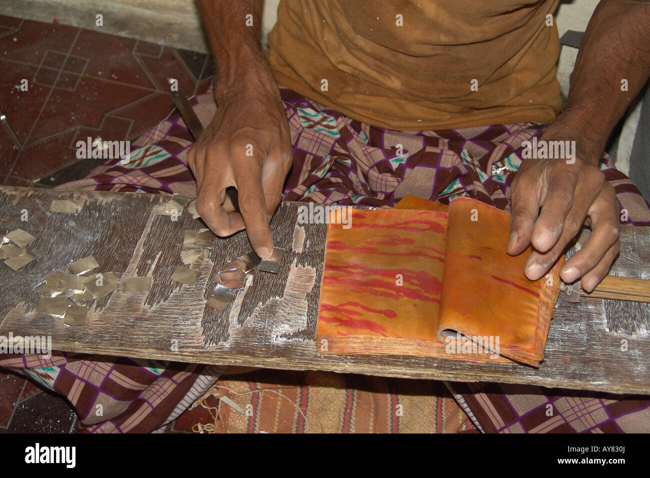 Workers making silver leaf or foil for fruits and sweets Stock Photo ...