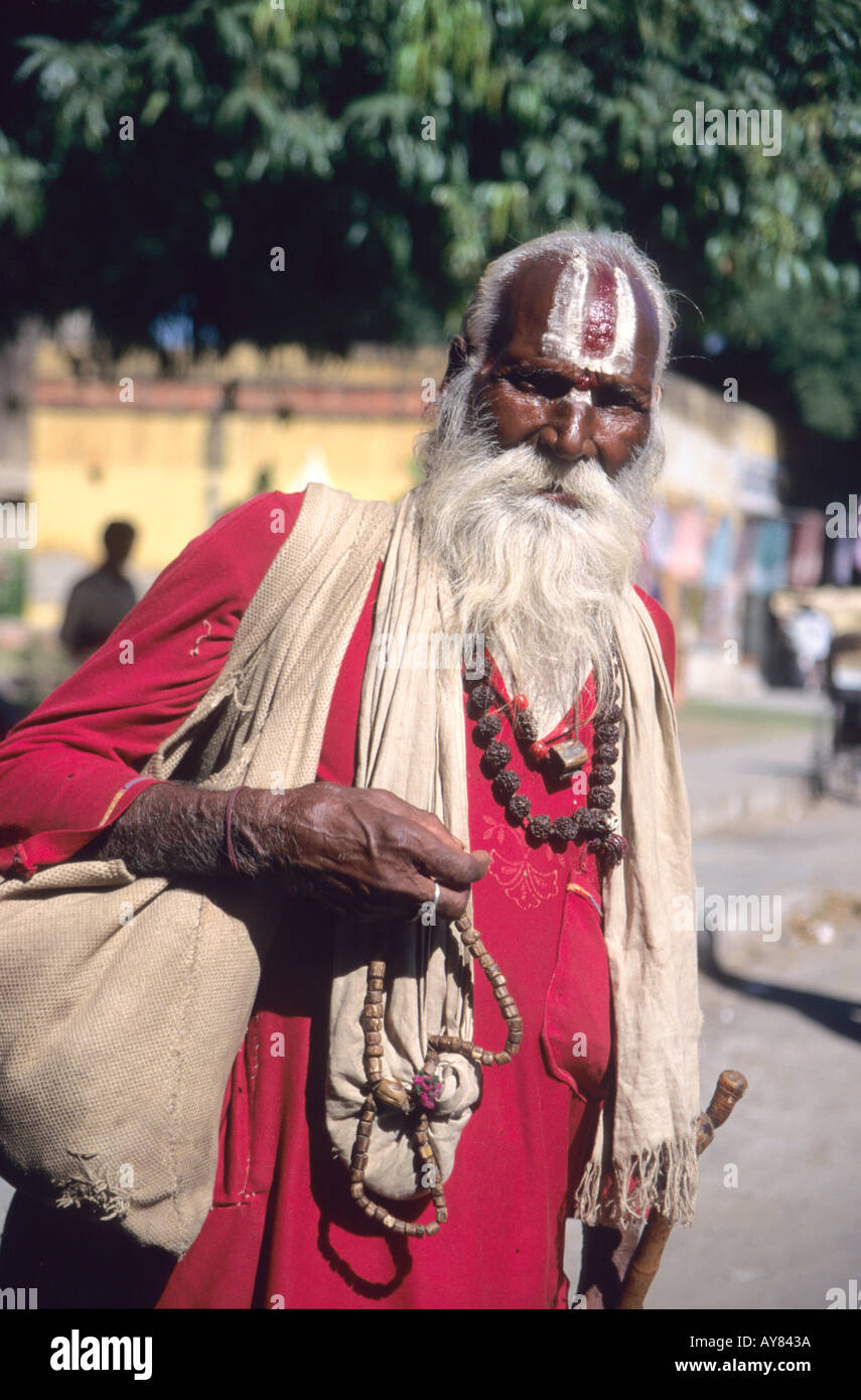 Red robed Saddhu with painted face waiting for alms in India Stock ...