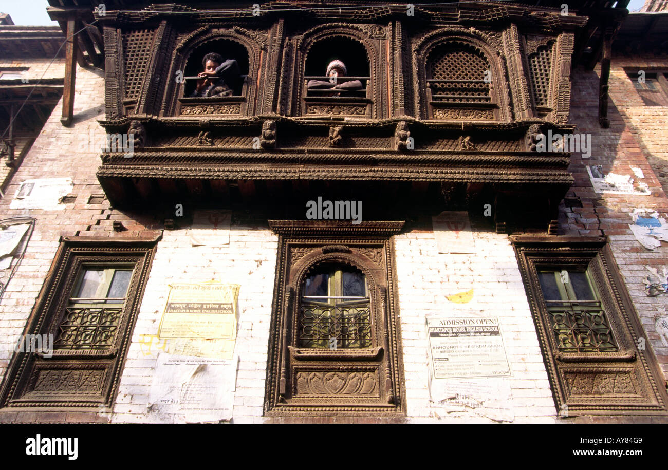 Nepal Thimi man looking out of decoratively carved 3rd floor window ...