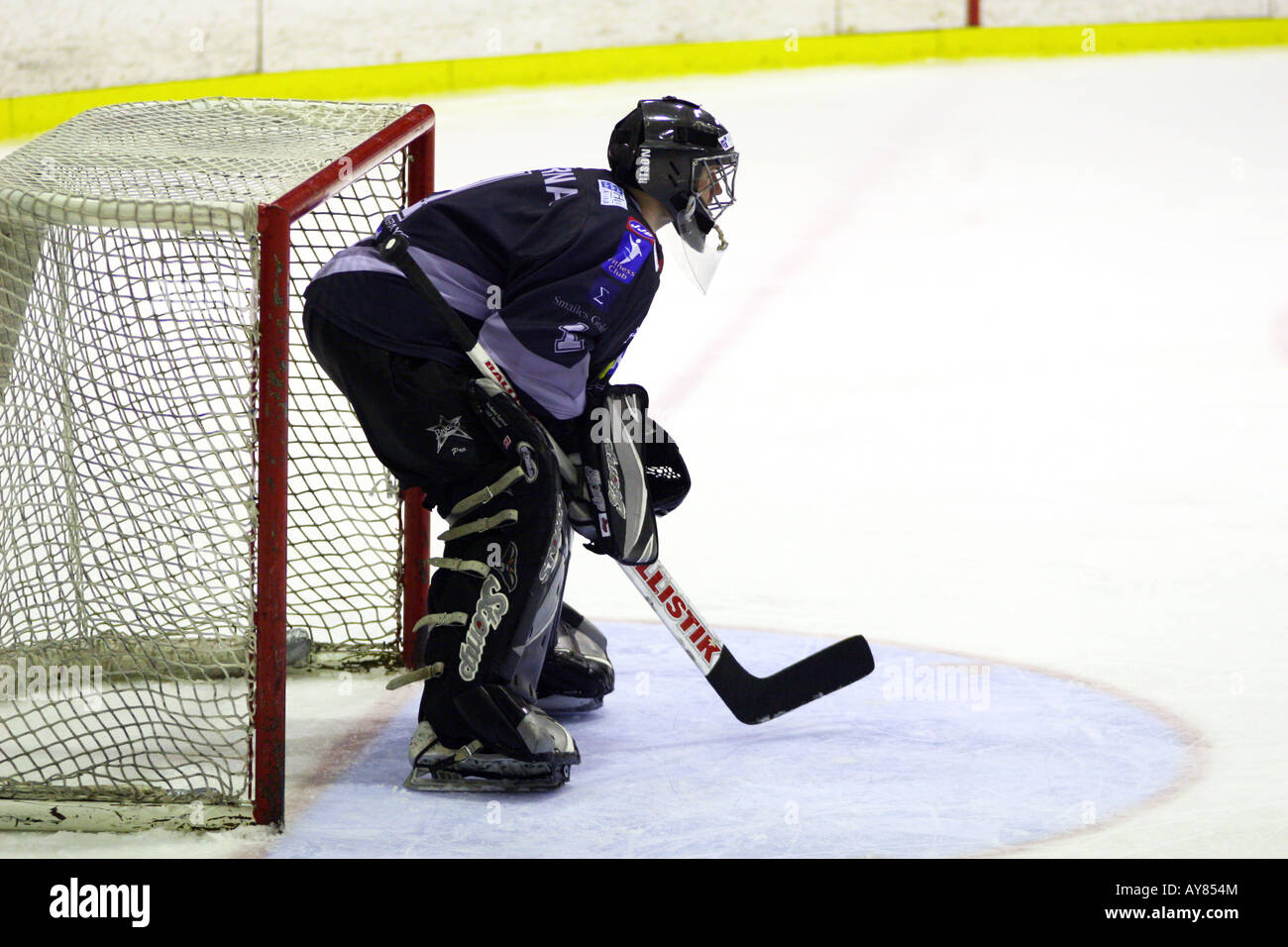 a lone Ice hockey goaltender waits for the action in front of the net ...