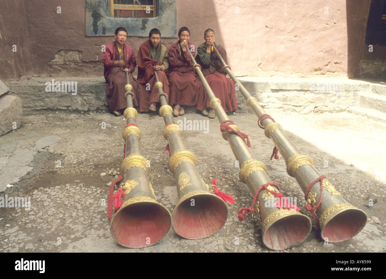 Monks playing the long horns Dung outside Tibetan monastery Stock Photo ...