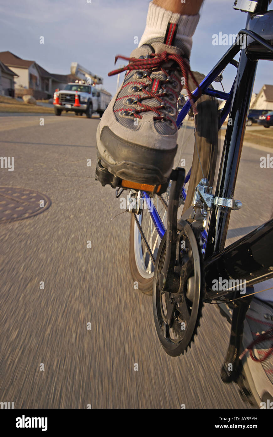 Low angle view of speeding cyclist foot on suburban street Stock Photo ...