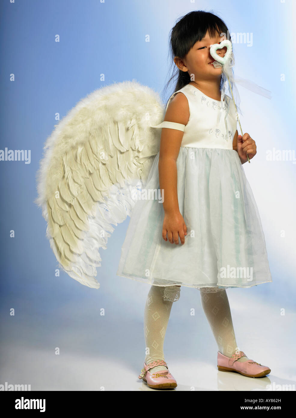 Happy kid covering her face with her magic stick Stock Photo - Alamy