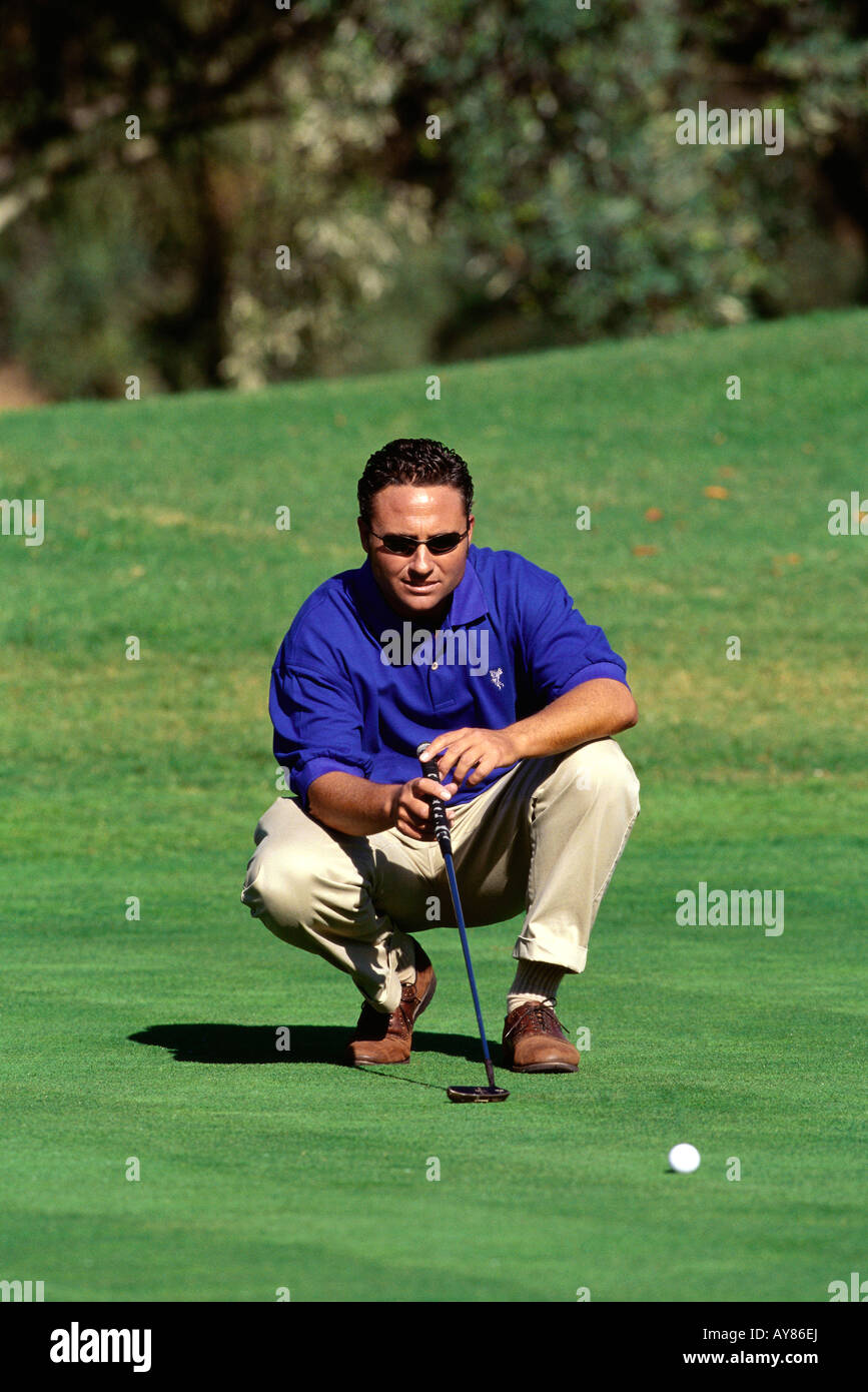 Male golfer lining up a putt Stock Photo - Alamy