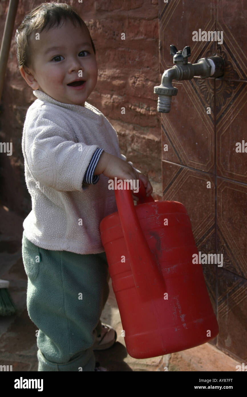 A young boy fills a water bucket Stock Photo - Alamy