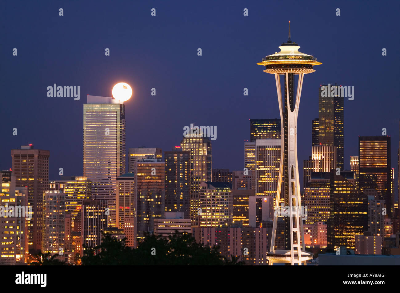 Seattle WA skyline near summer solstice with full moon behind USA flag ...