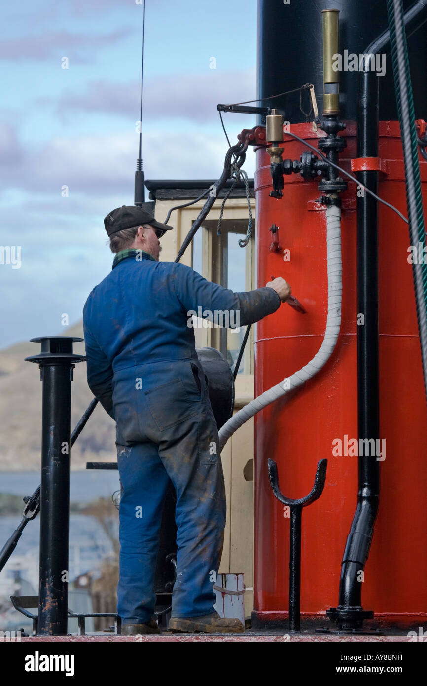 A man painting the funnel of an old steam puffer boat Scotland Stock ...