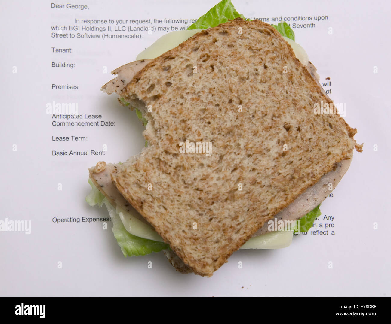 Office desk of busy office worker with bite out of sandwich Stock Photo ...