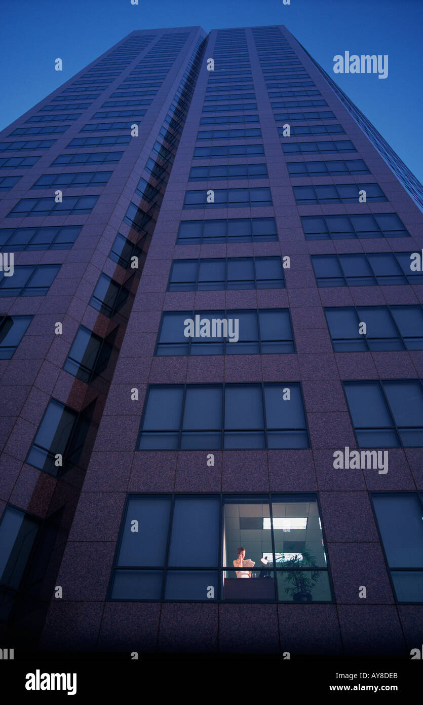 Female office worker is working later in highrise office building Stock ...