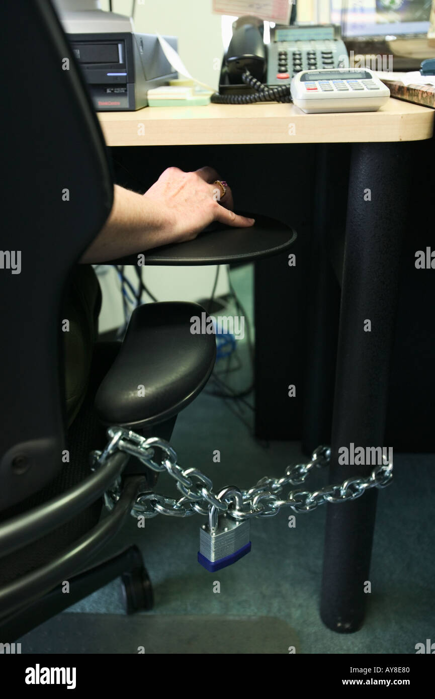 Office employee executive is chained to office desk and chair Stock ...