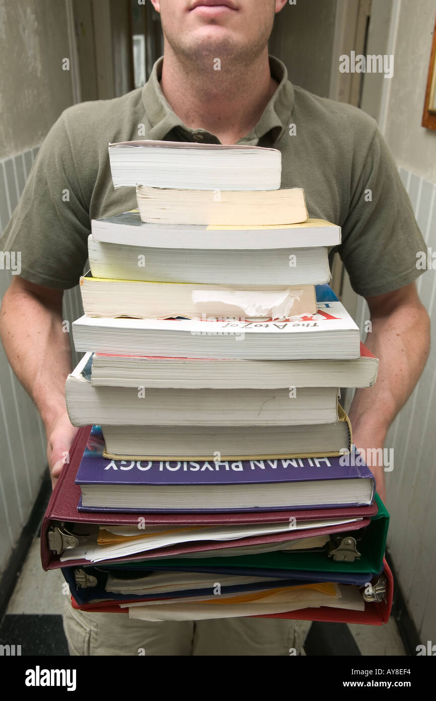 Student holding a stack of books at Fraternity House in Southern ...