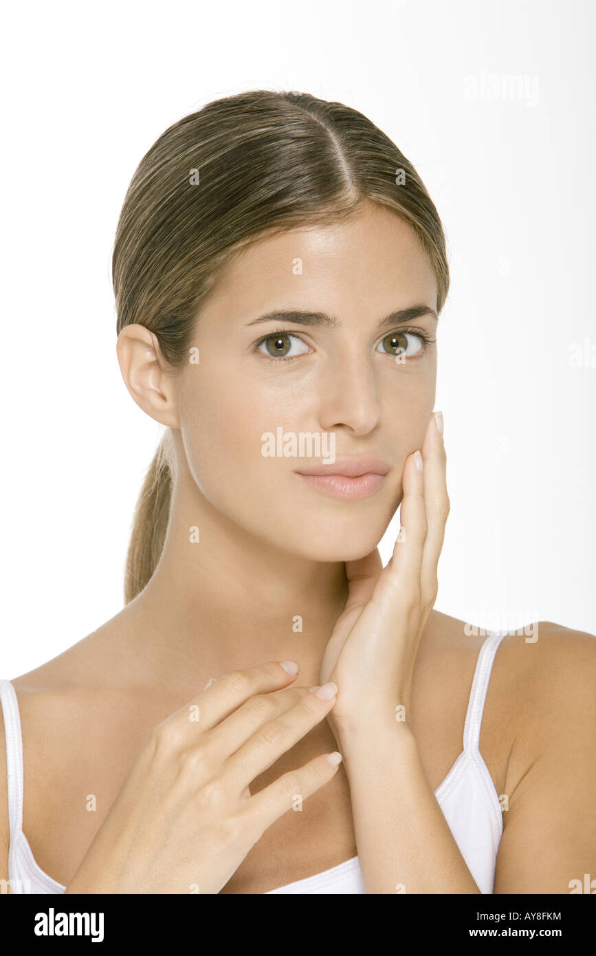 Woman touching cheek, smiling at camera, portrait Stock Photo - Alamy