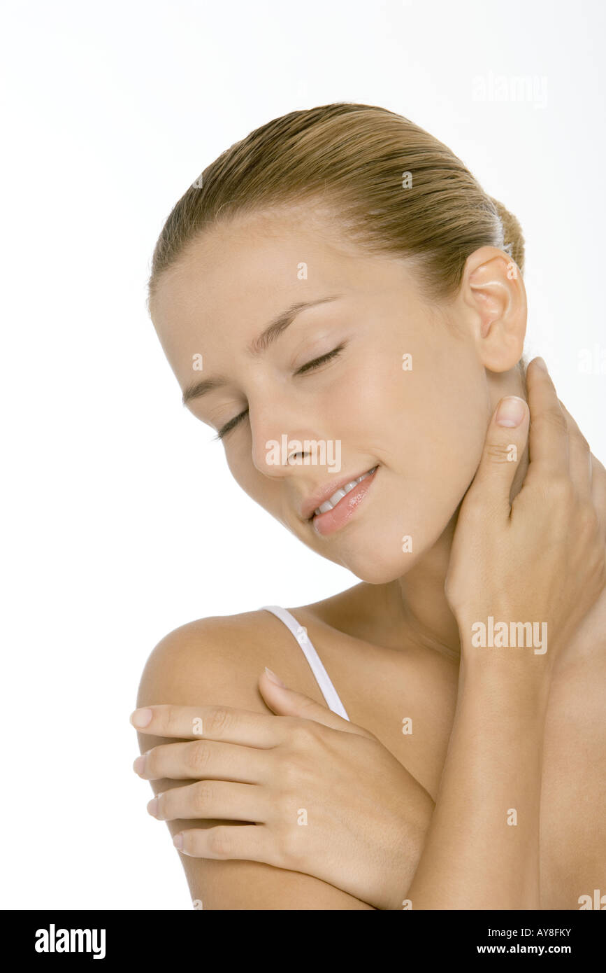 Young woman touching neck and shoulder, smiling, eyes closed Stock ...