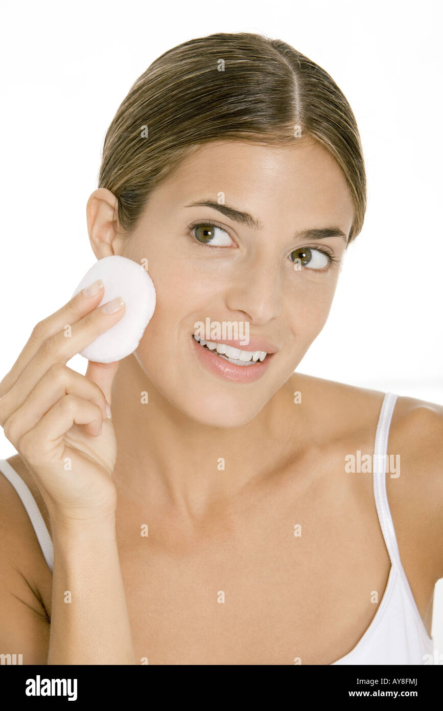 Woman using powder puff on cheek, smiling Stock Photo - Alamy