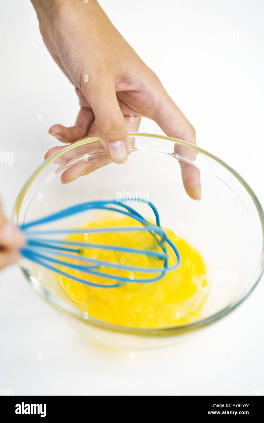 Woman whisking eggs in bowl, cropped, high angle view Stock Photo - Alamy