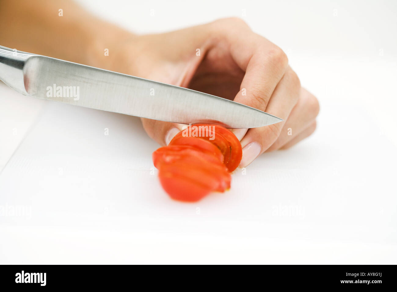 Woman slicing tomato with knife, cropped view of hand Stock Photo - Alamy