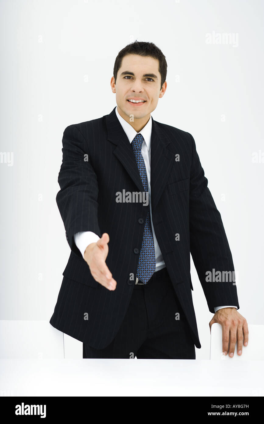 Businessman extending hand toward camera, smiling Stock Photo - Alamy