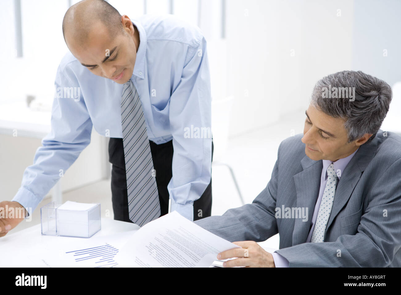 Two businessmen looking over documents together Stock Photo - Alamy