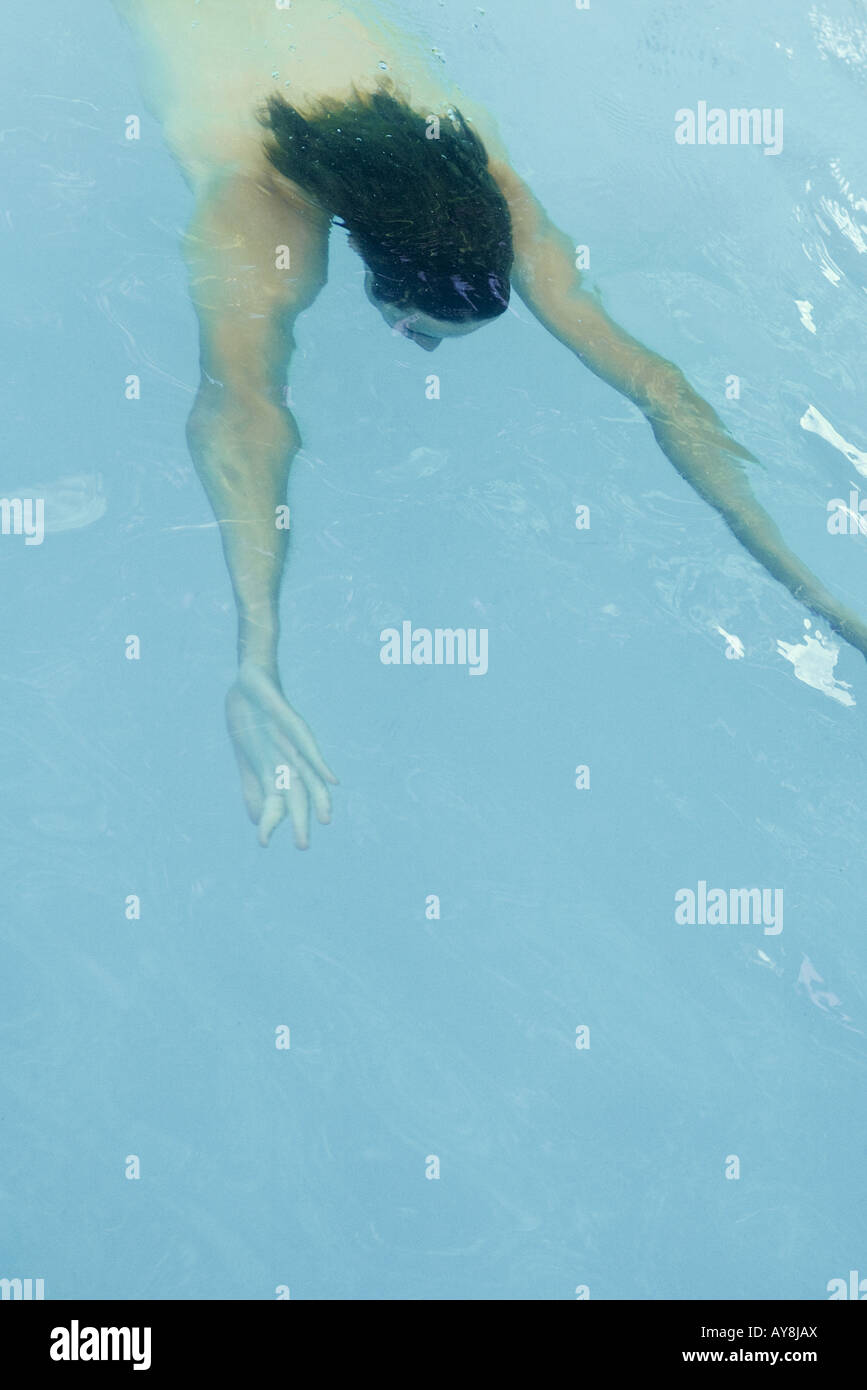 Man swimming underwater in pool, arms stretched in front of him Stock ...