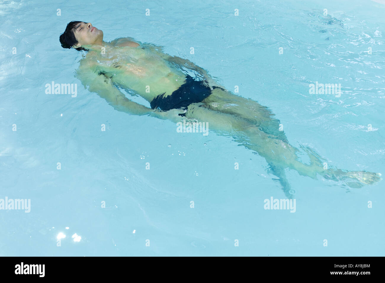 Man floating on back in swimming pool, eyes closed Stock Photo - Alamy