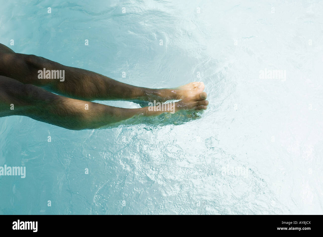 Man soaking feet in swimming pool, high angle view, cropped Stock Photo ...
