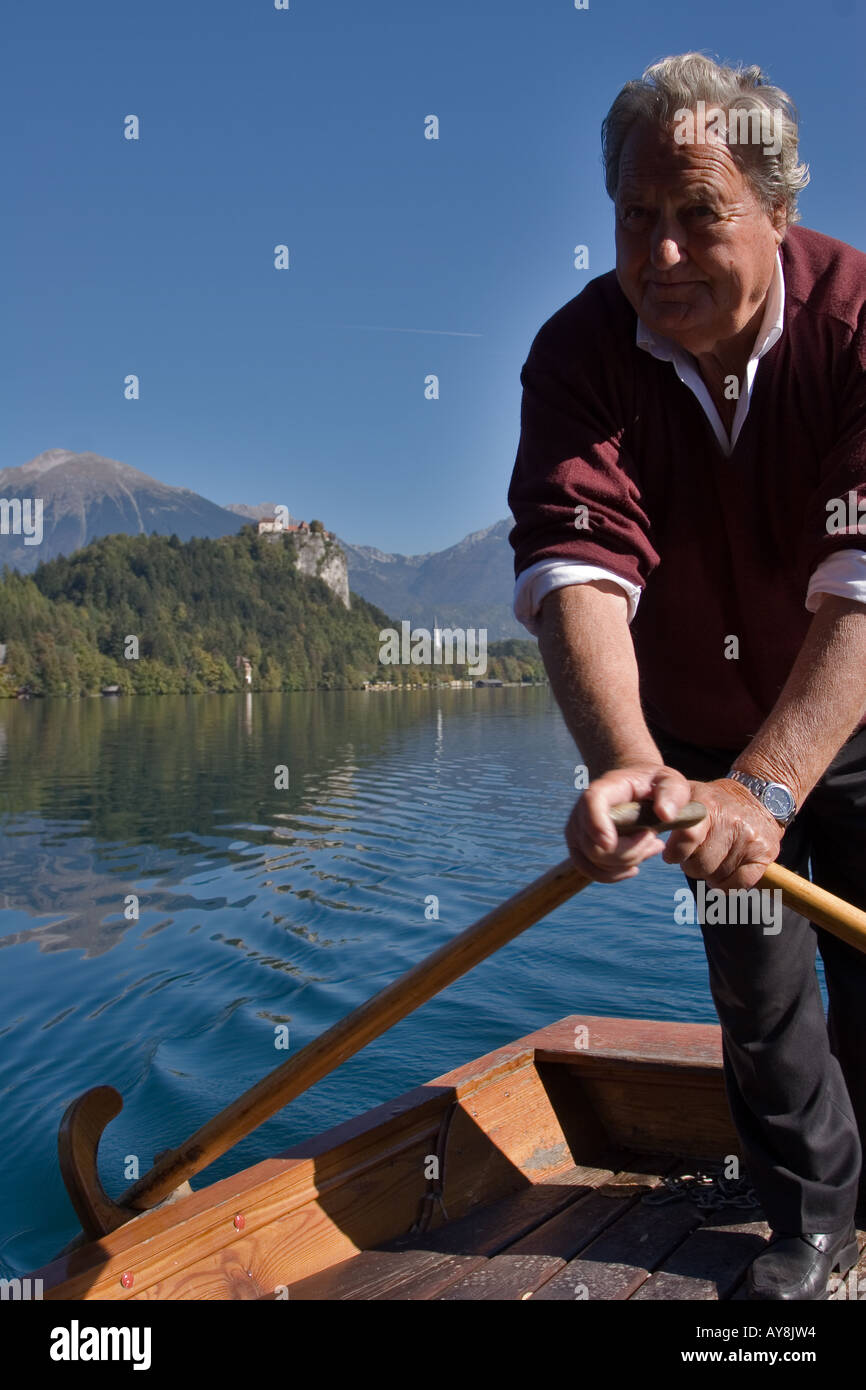 Stock Photo of Man Rowing With Oars Aboard a Boat In The Lake of Bled ...