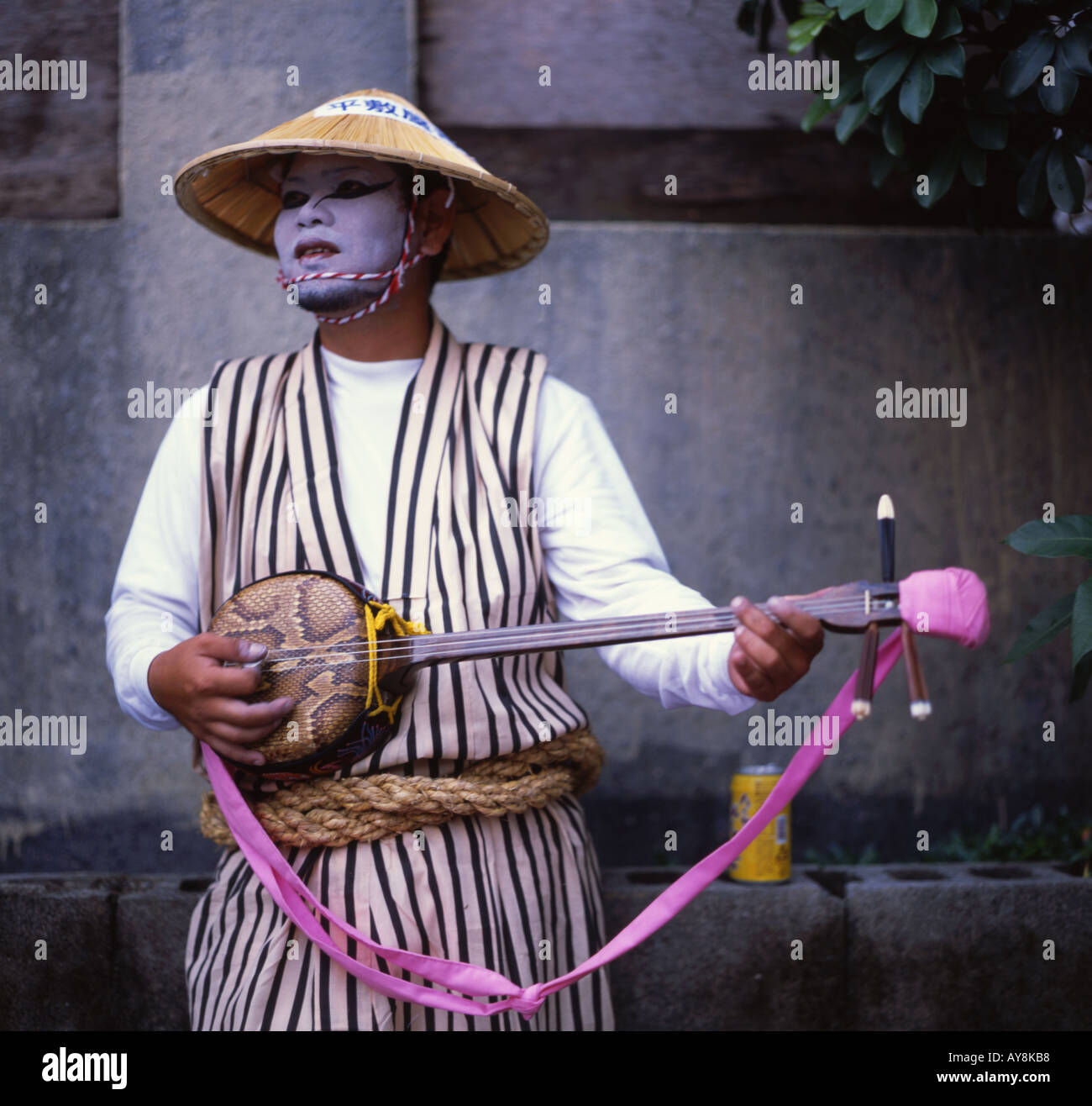 Man with sanshin and painted face at traditional Okinawan Eisa festival ...