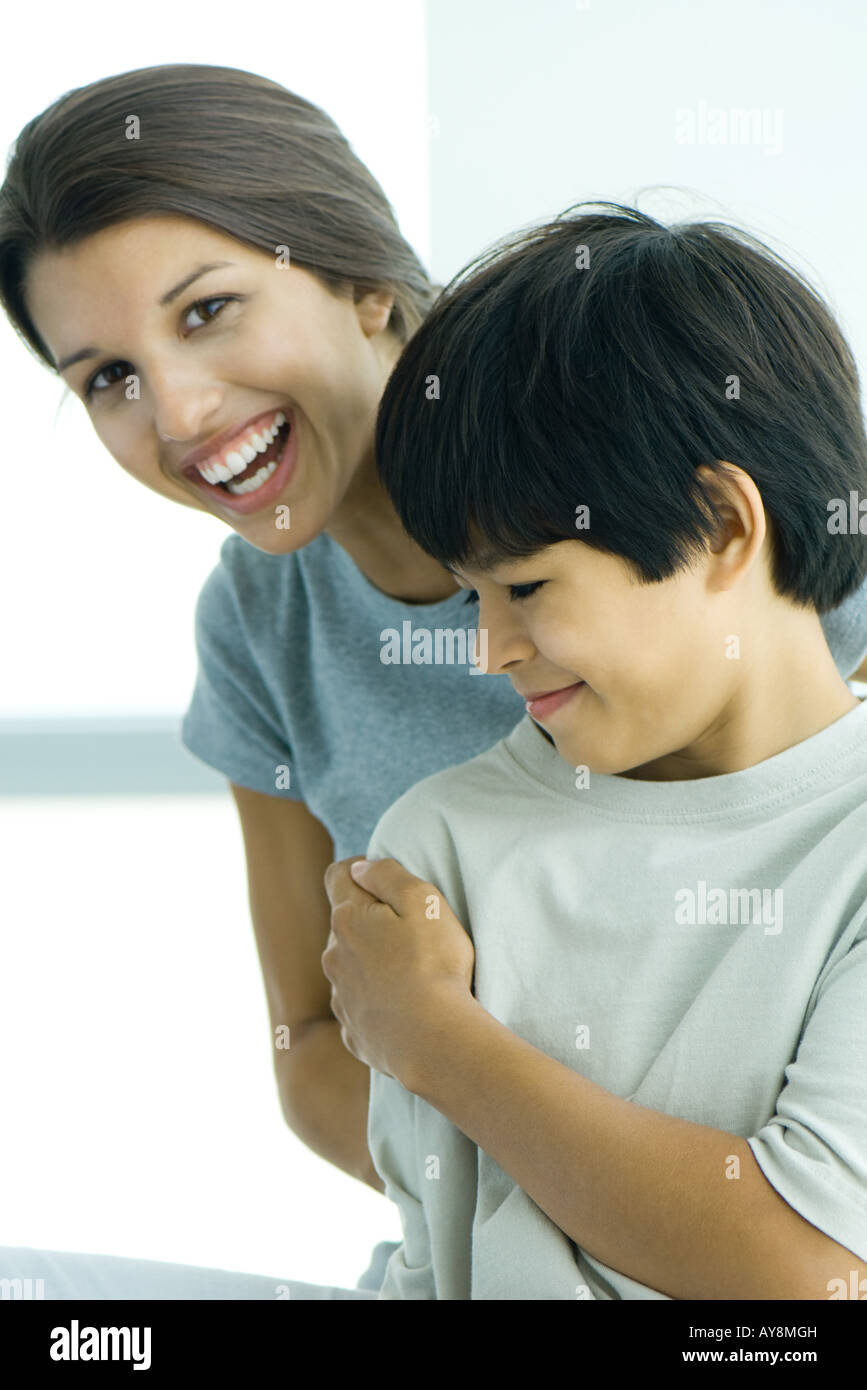 Teenage girl looking over boy's shoulder at camera, both smiling Stock ...