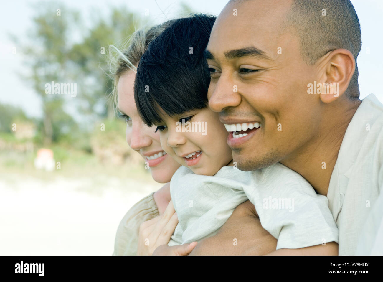 Family cheek to cheek, smiling together, side view Stock Photo - Alamy