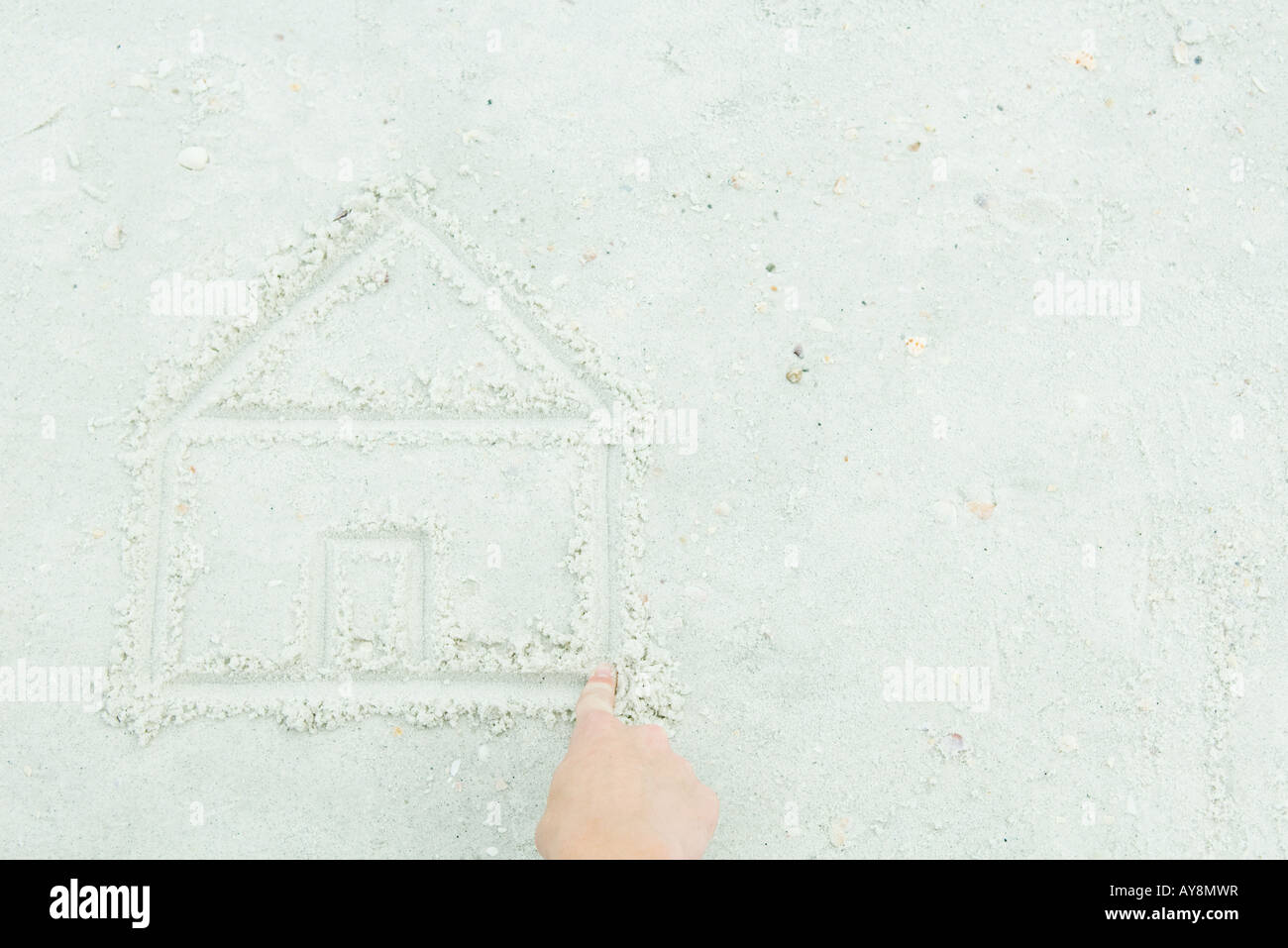 Hand drawing house in sand, cropped view Stock Photo - Alamy