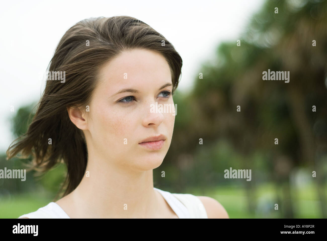 Teen girl looking away, hair blowing in wind, head and shoulders Stock ...