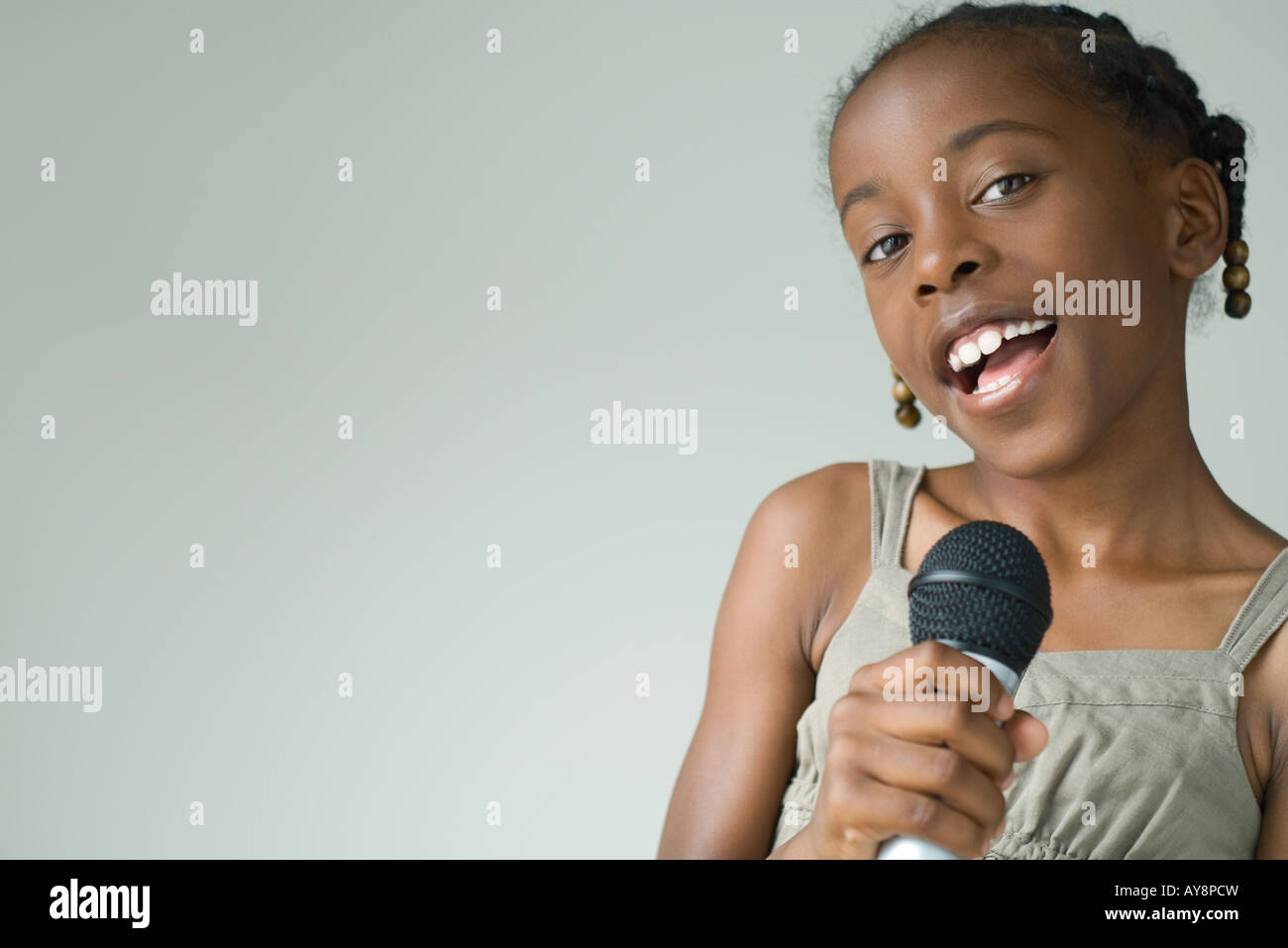 Little girl singing into microphone, smiling at camera, close-up Stock ...