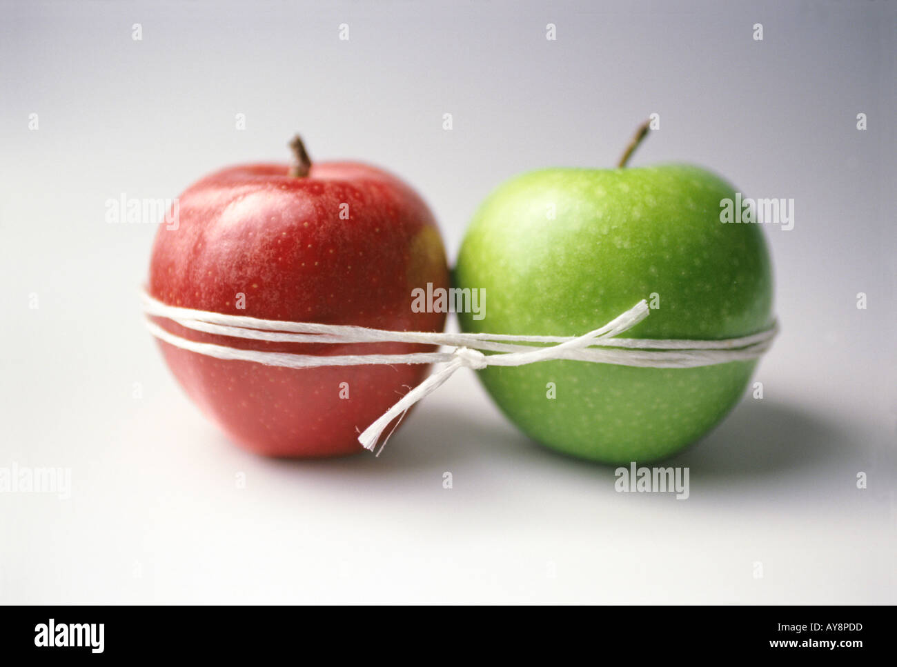 "Red apple, green apple, "tied together" with string Stock Photo - Alamy