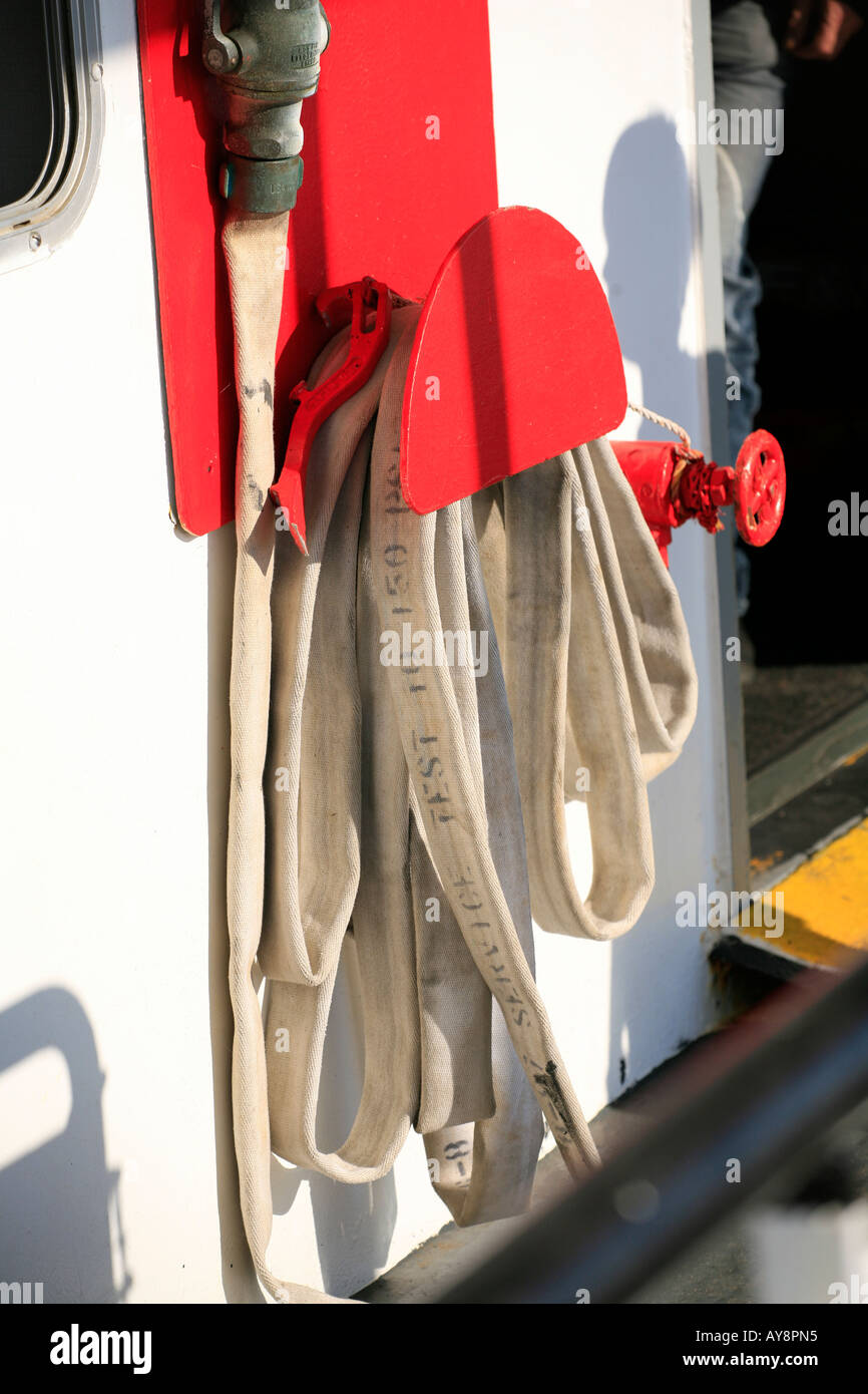 Fire hose hanging on ship wall Stock Photo - Alamy