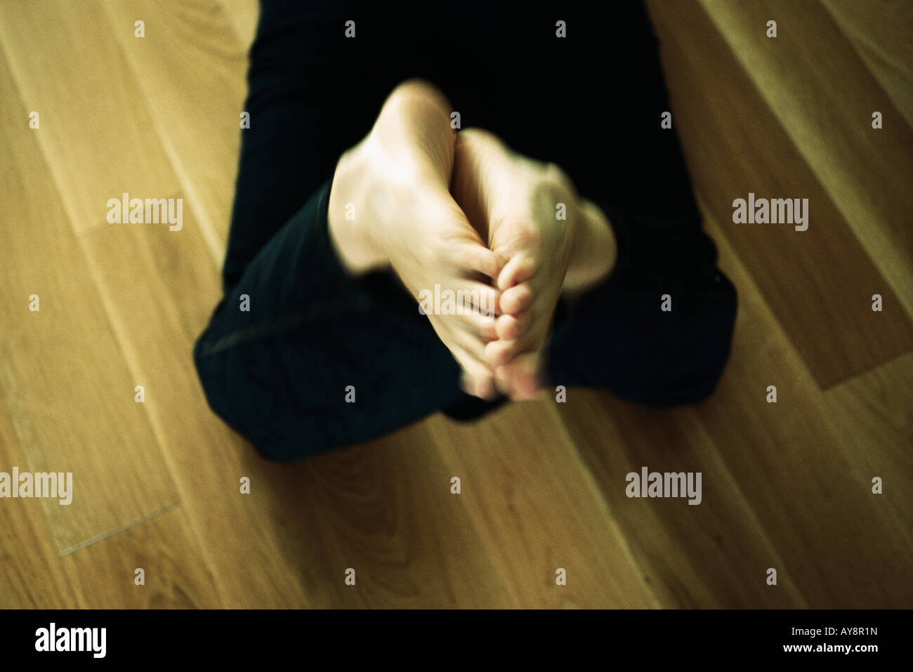 Person lying on floor, bare feet raised, cropped view Stock Photo - Alamy