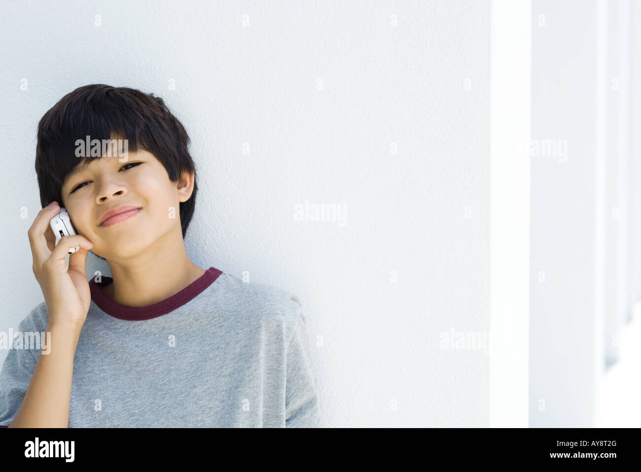Boy using cell phone, smiling at camera Stock Photo - Alamy