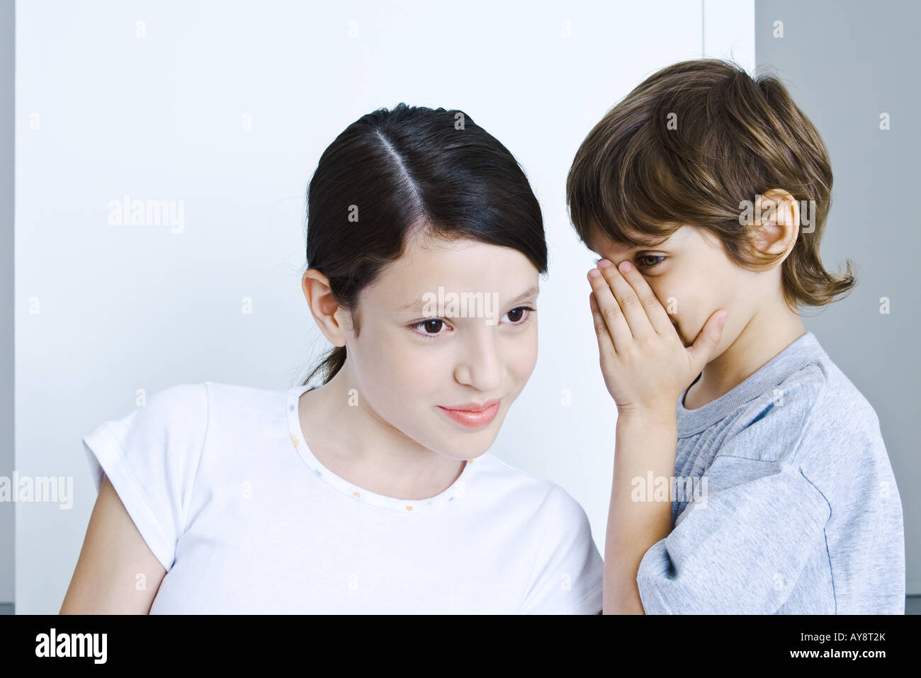 Little boy whispering in sister's ear, girl smiling Stock Photo - Alamy