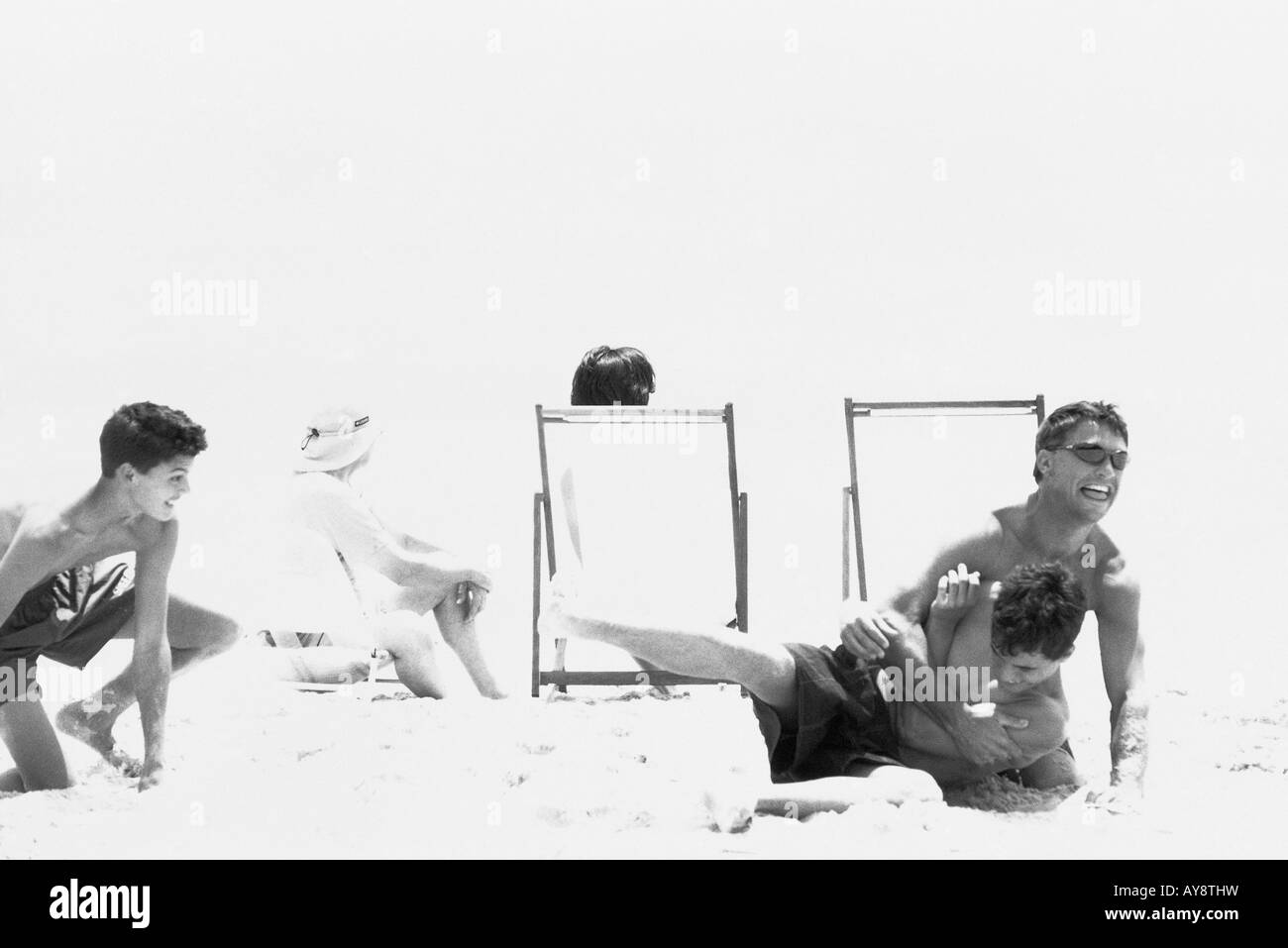 Father and two teen sons roughhousing on beach Stock Photo - Alamy