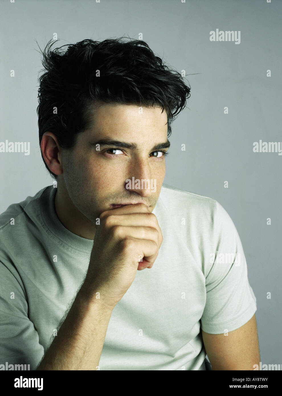 Man with hand under chin, looking at camera, portrait Stock Photo - Alamy