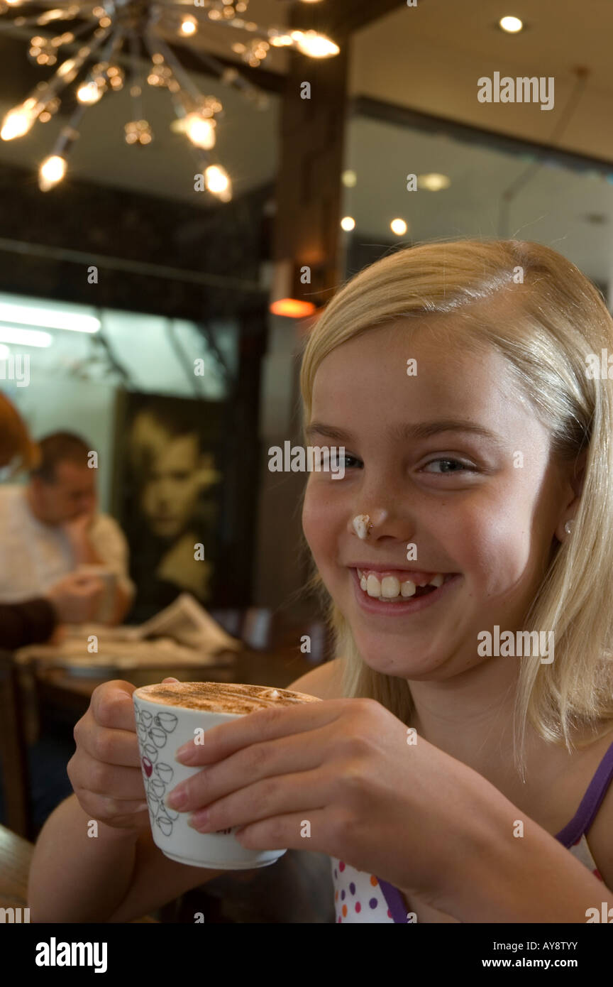 Girl in Cafe drinking hot chocolate with cream on nose Stock Photo - Alamy