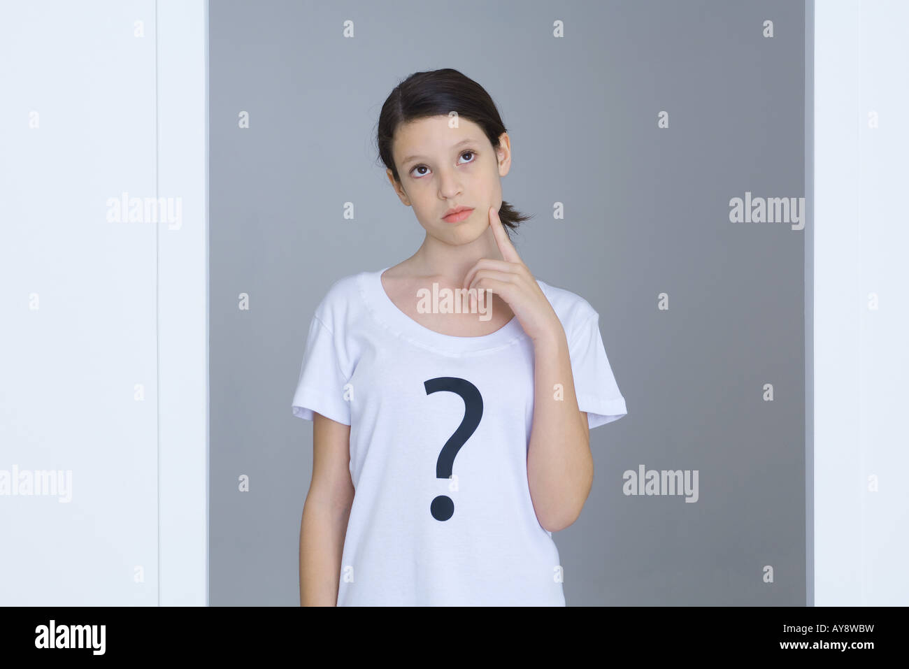 Girl wearing tee-shirt printed with question mark, touching face ...