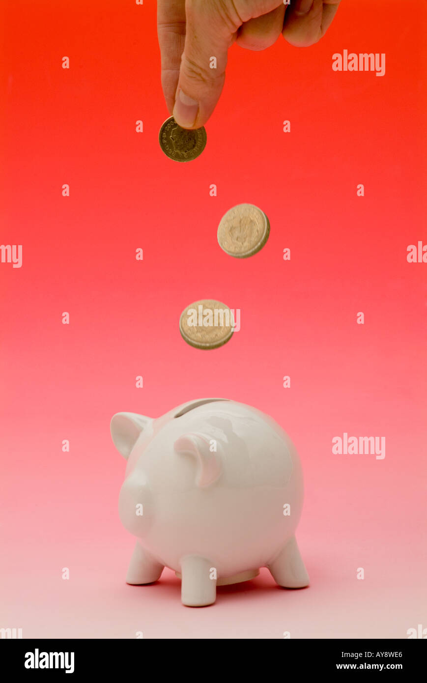 Hand dropping coins into a piggy bank hi-res stock photography and ...