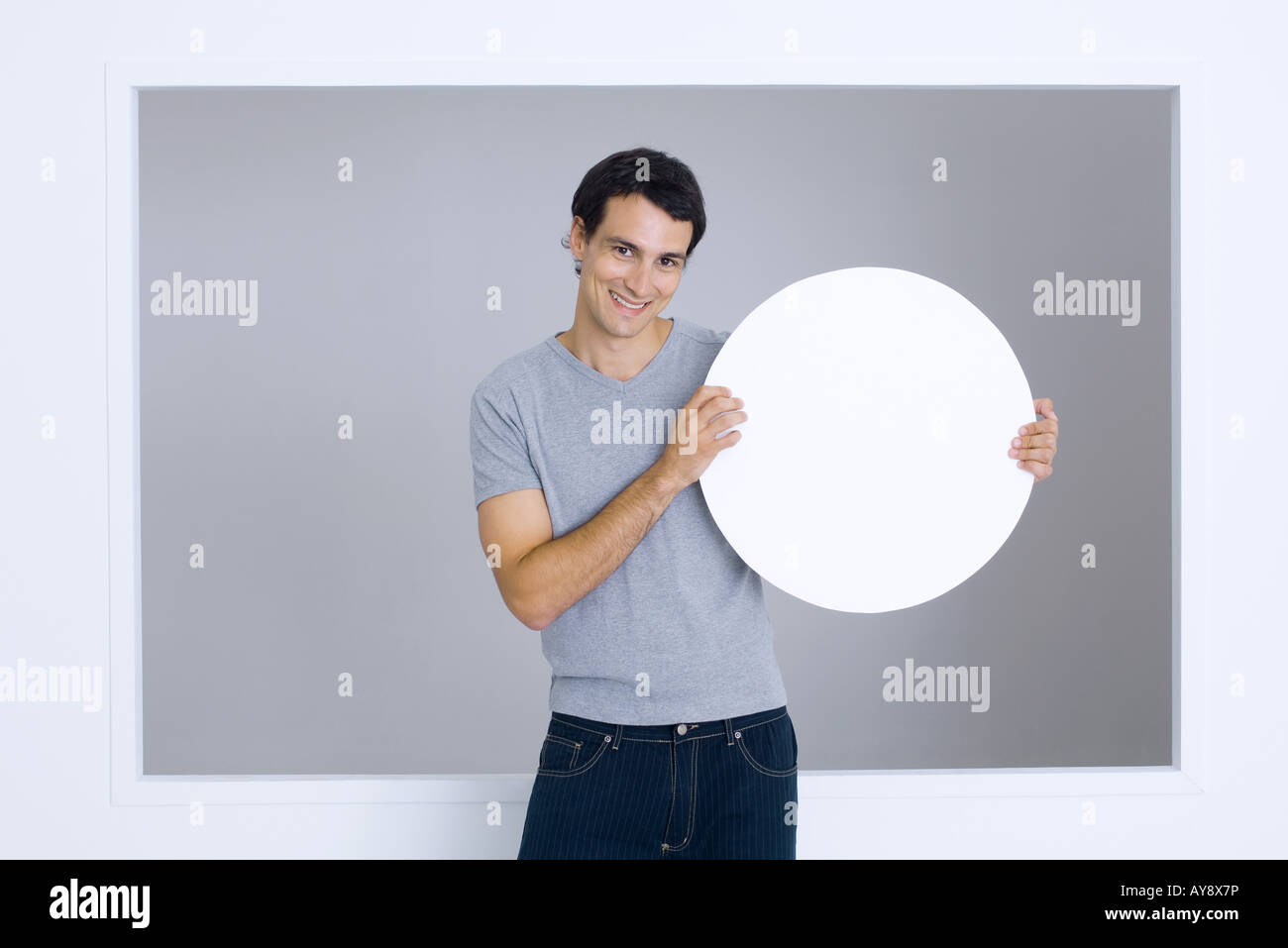 Man holding up round sign, smiling at camera Stock Photo - Alamy