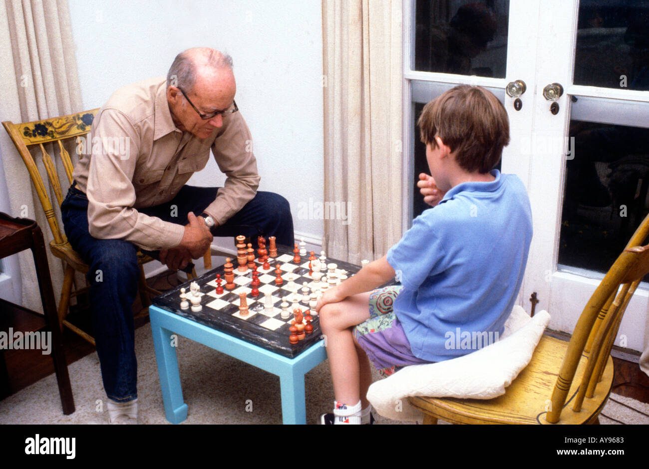 grandfather playing a game of chess with his young grandson Stock Photo ...