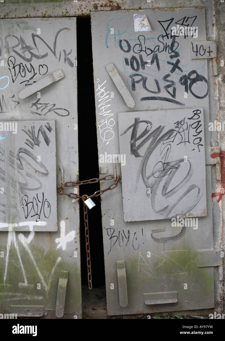 crooked metal doors with chain and padlock, graffiti Stock Photo - Alamy