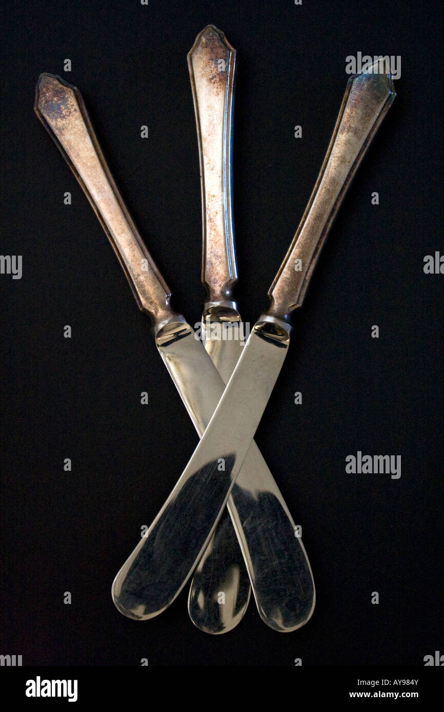 A colour image of three silver knives with blades crossing Stock Photo ...