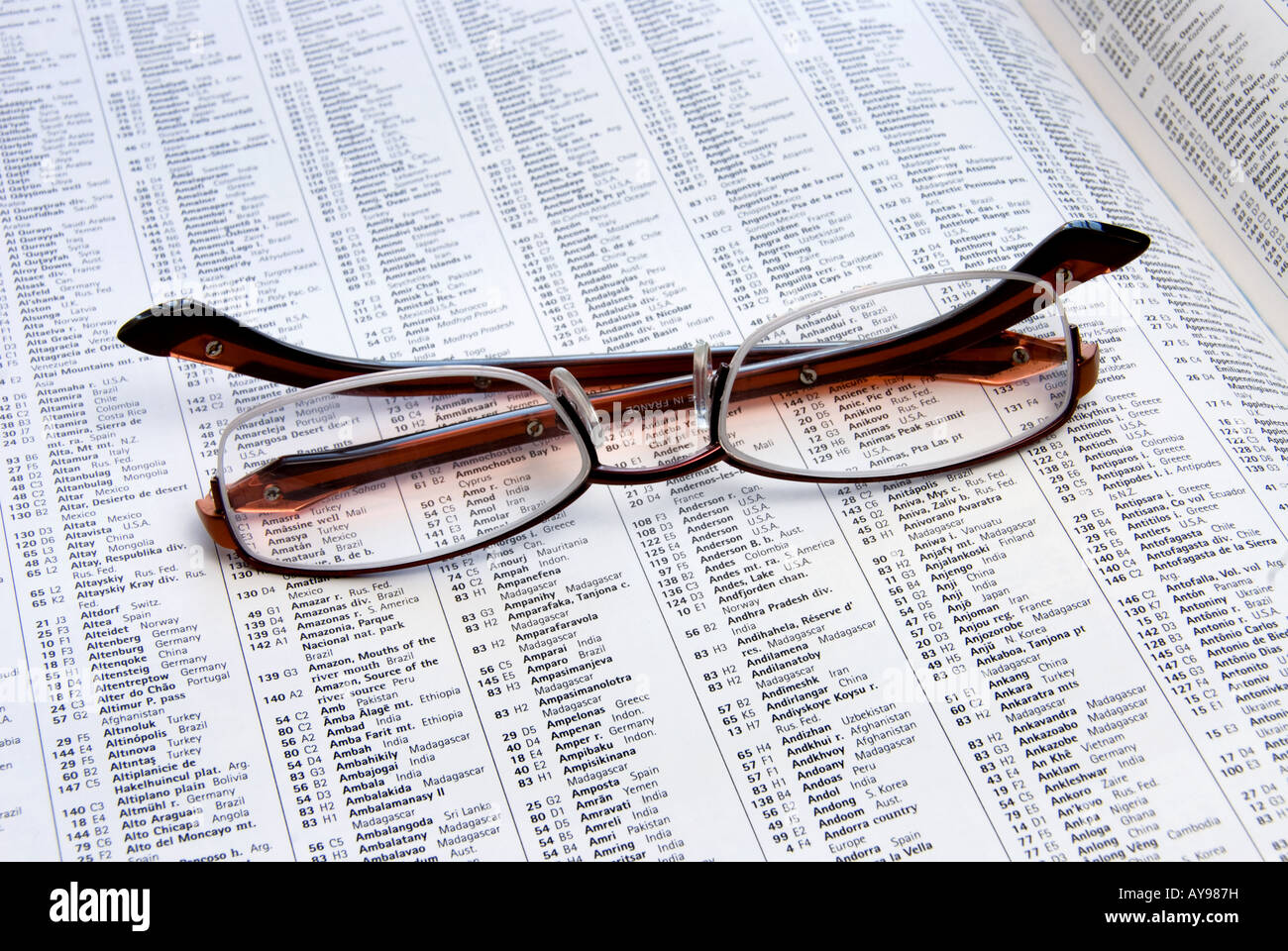 Reading glasses on a map depicts the need to view small fonts printed ...