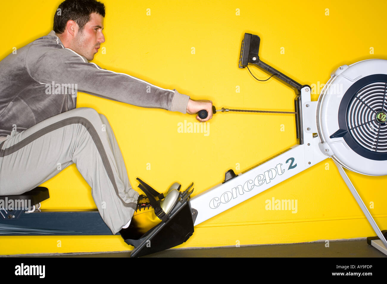 Man on a rowing machine, working out Stock Photo - Alamy